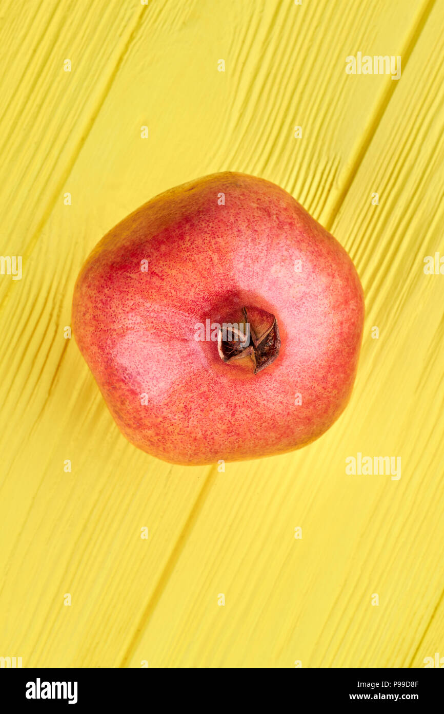 Fresh ripe pomegranate, top view. Healthy pomegranate fruit on yellow ...