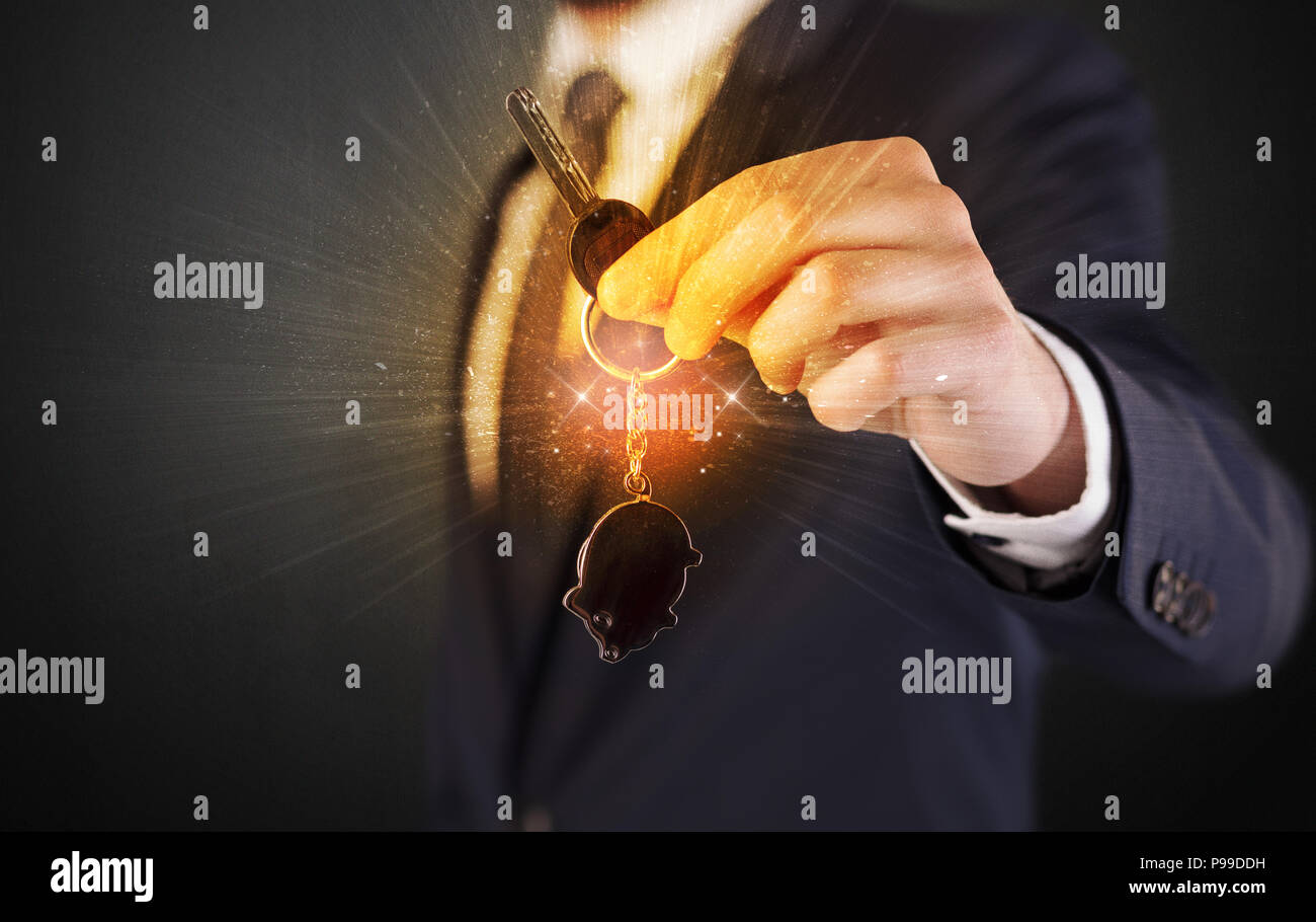 Formal man hand over shiny keys with dark background Stock Photo - Alamy