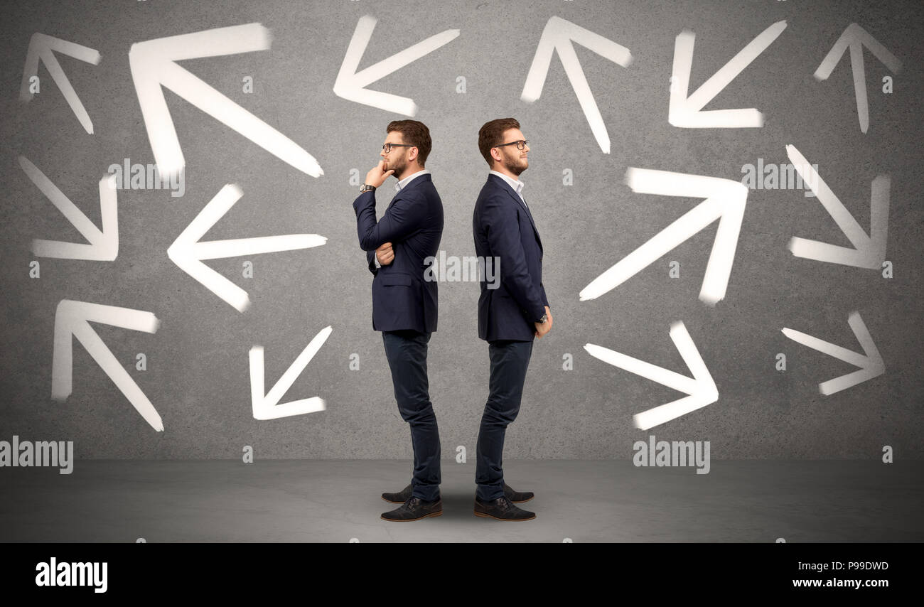 Young conflicted businessman choosing between two directions with ...
