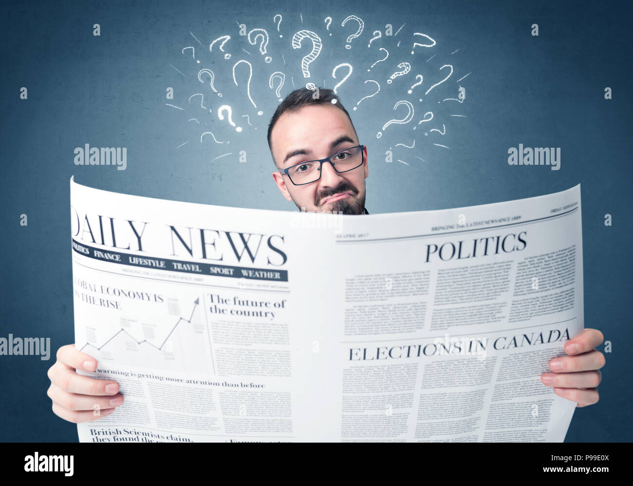 Young confused businessman reading daily newspaper with question marks ...