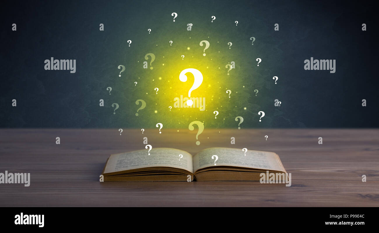 Yellow question marks hovering over open book Stock Photo - Alamy