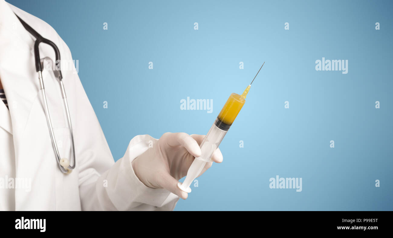 Female doctor hand holding syringe with blue background Stock Photo - Alamy