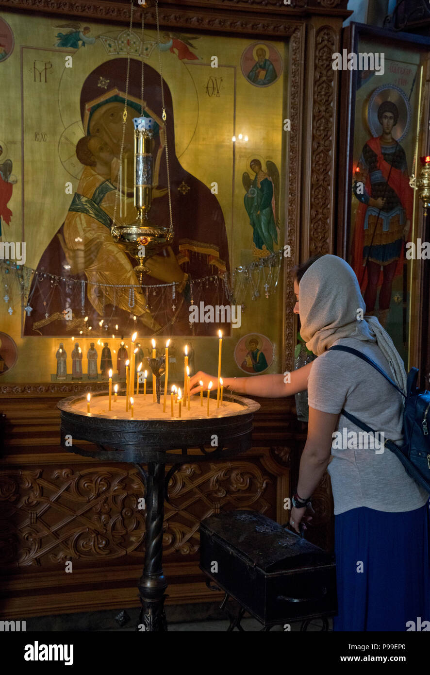 Woman lighting candles at a Russian Orthodox church service at the ...