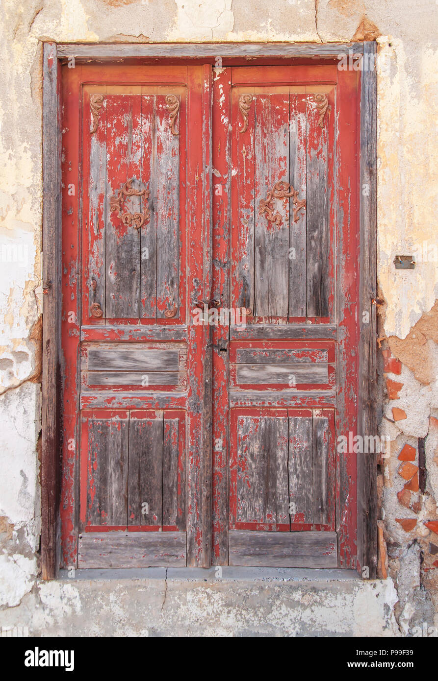 Dirty wooden broken and closed red door in rural old town Stock Photo ...