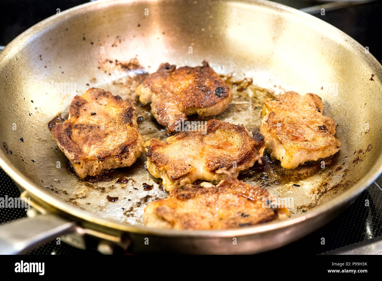 fried meat in a frying pan, cooking Stock Photo - Alamy