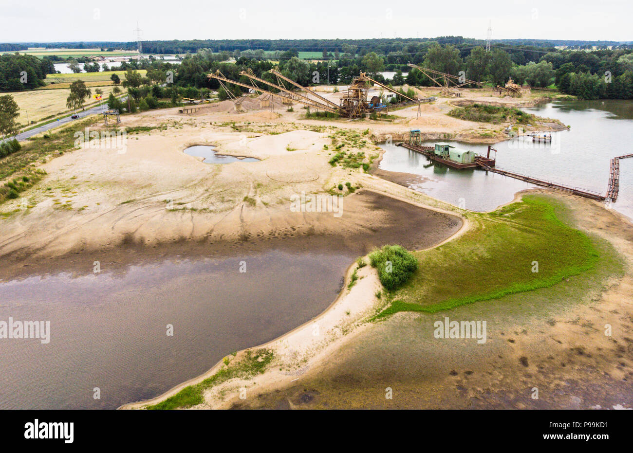 Aerial view of a wet quarry for gravel and sand with large machines for ...