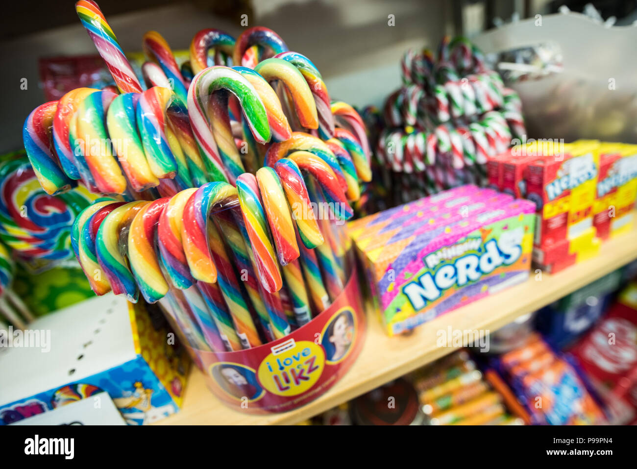Bright rainbow-coloured traditional candy sticks on a packed sweet shop ...