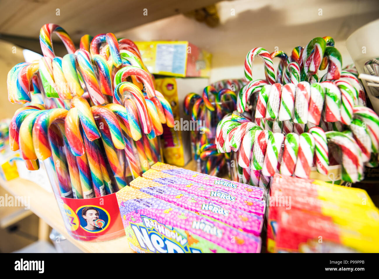 Bright rainbow-coloured traditional candy sticks on a packed sweet shop ...