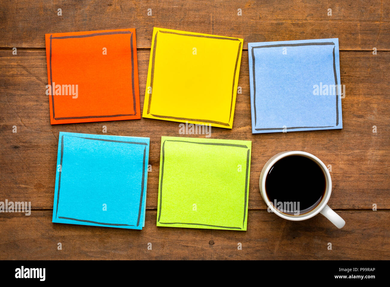 set of colorful, blank reminder notes on a grunge wooden table with a ...