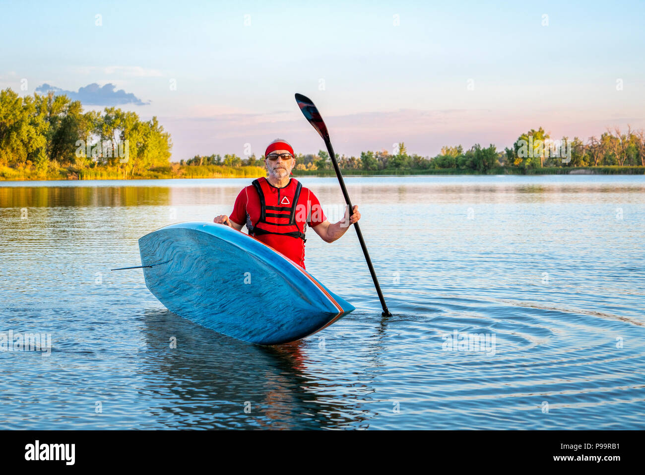 Environmental portrait of a senior male paddler with a stand up ...
