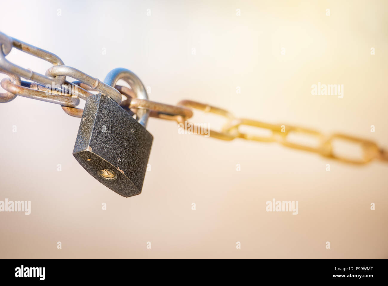 metal lock with chain on blurred Sunny background Stock Photo - Alamy