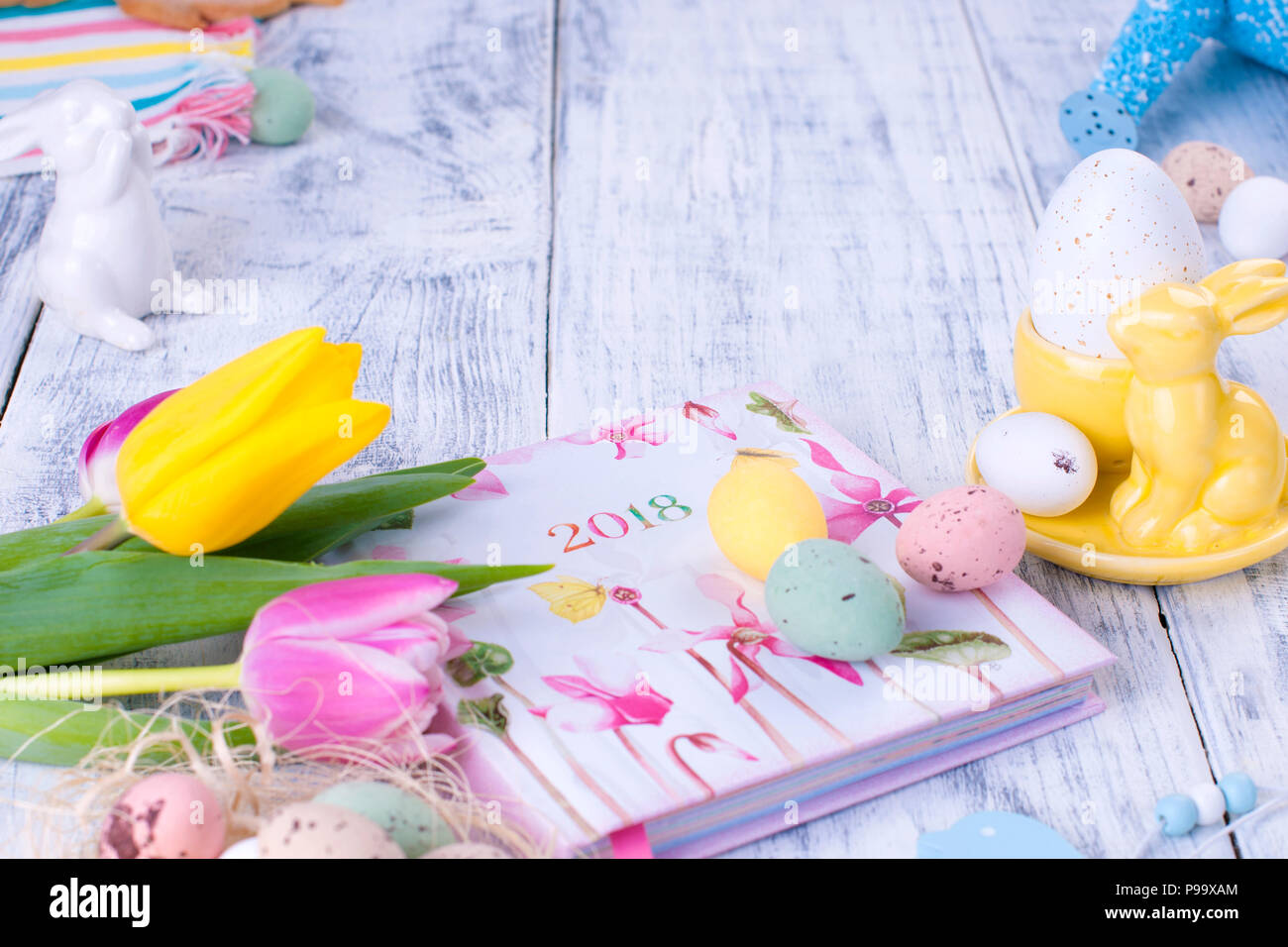 The tulips are pink and yellow in a vase on the table. White background ...