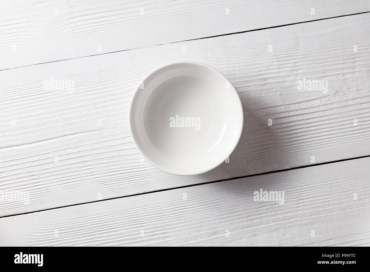 One empty plate on a white wooden kitchen table. Top view Stock Photo ...