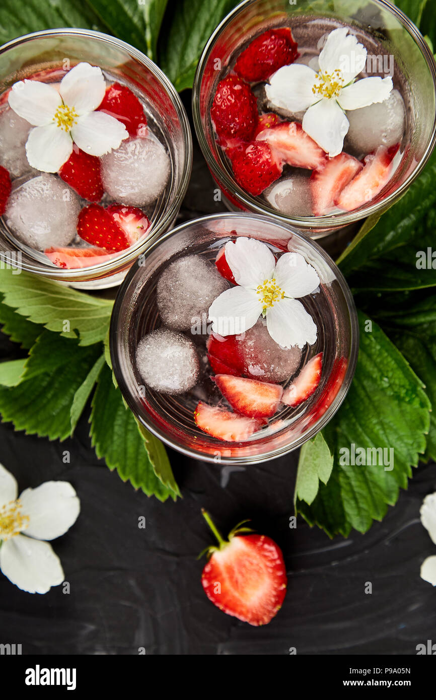 Strawberry detox water with jasmine flower. Summer iced drink or tea ...