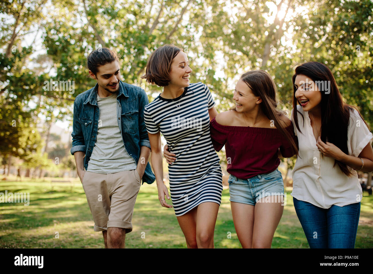 Portrait of three women and young man walking and enjoying together at ...