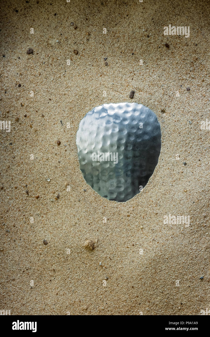Metal orb half buried in sand Stock Photo - Alamy