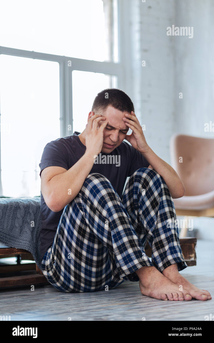 Miserable man holding his head Stock Photo - Alamy