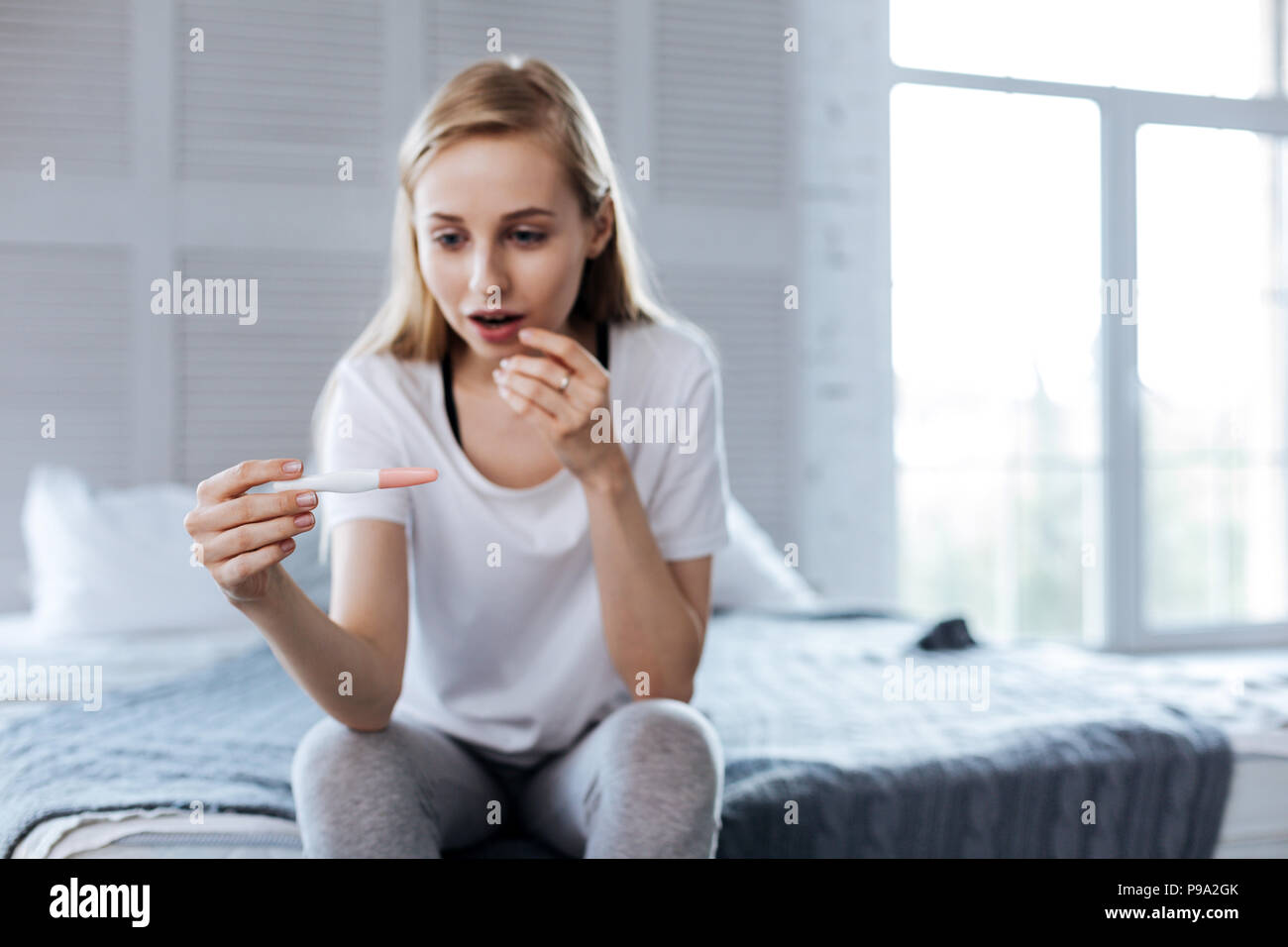 Cheerful woman holding her pregnancy test Stock Photo - Alamy
