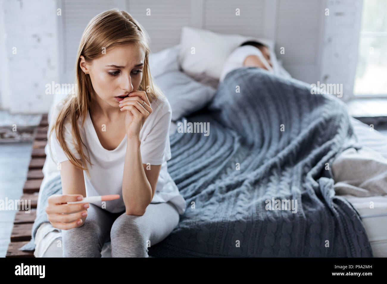 Preoccupied woman holding her pregnancy test Stock Photo - Alamy