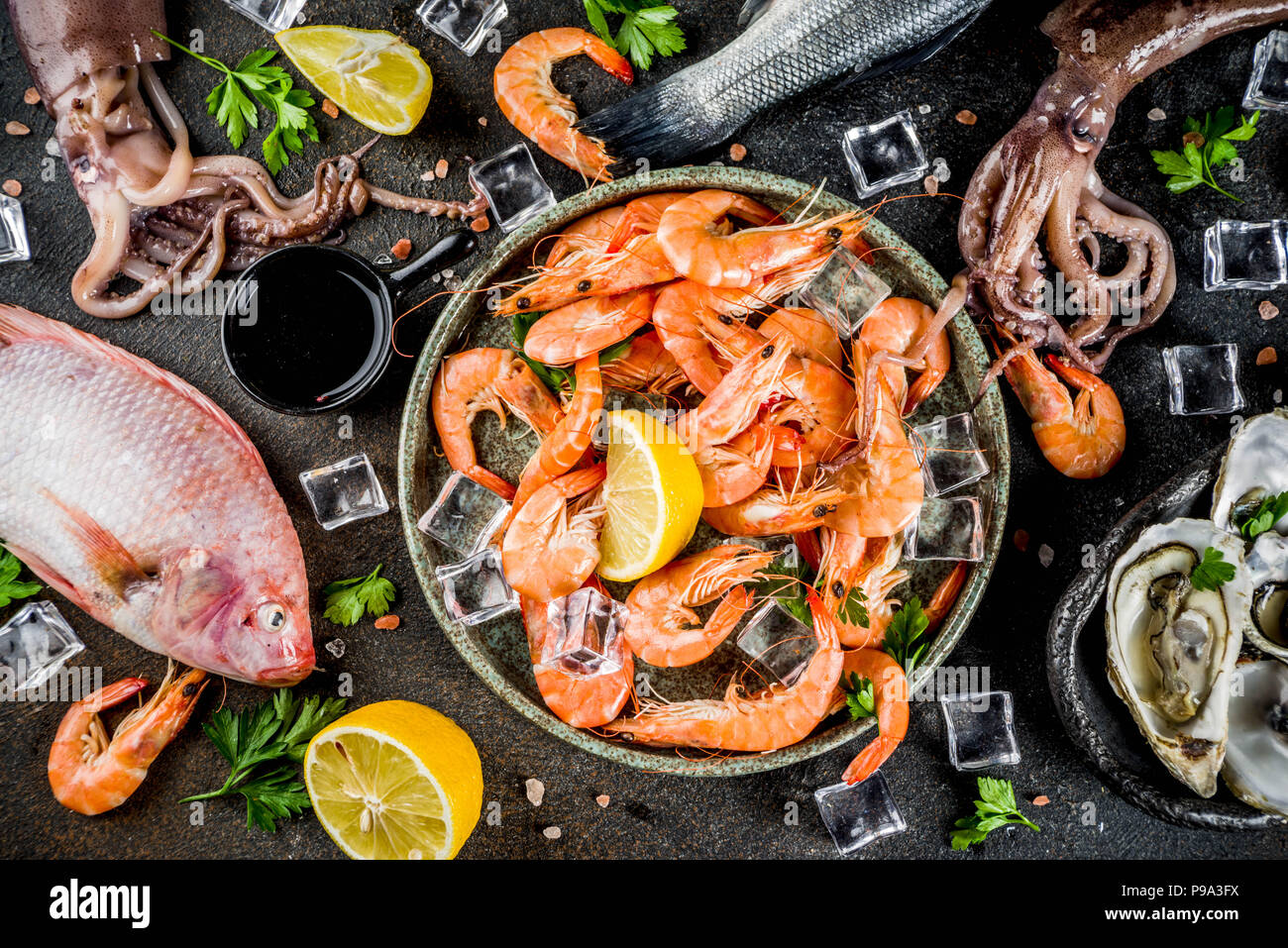 Fresh raw seafood squid shrimp oyster mussels fish with spices of herbs ...