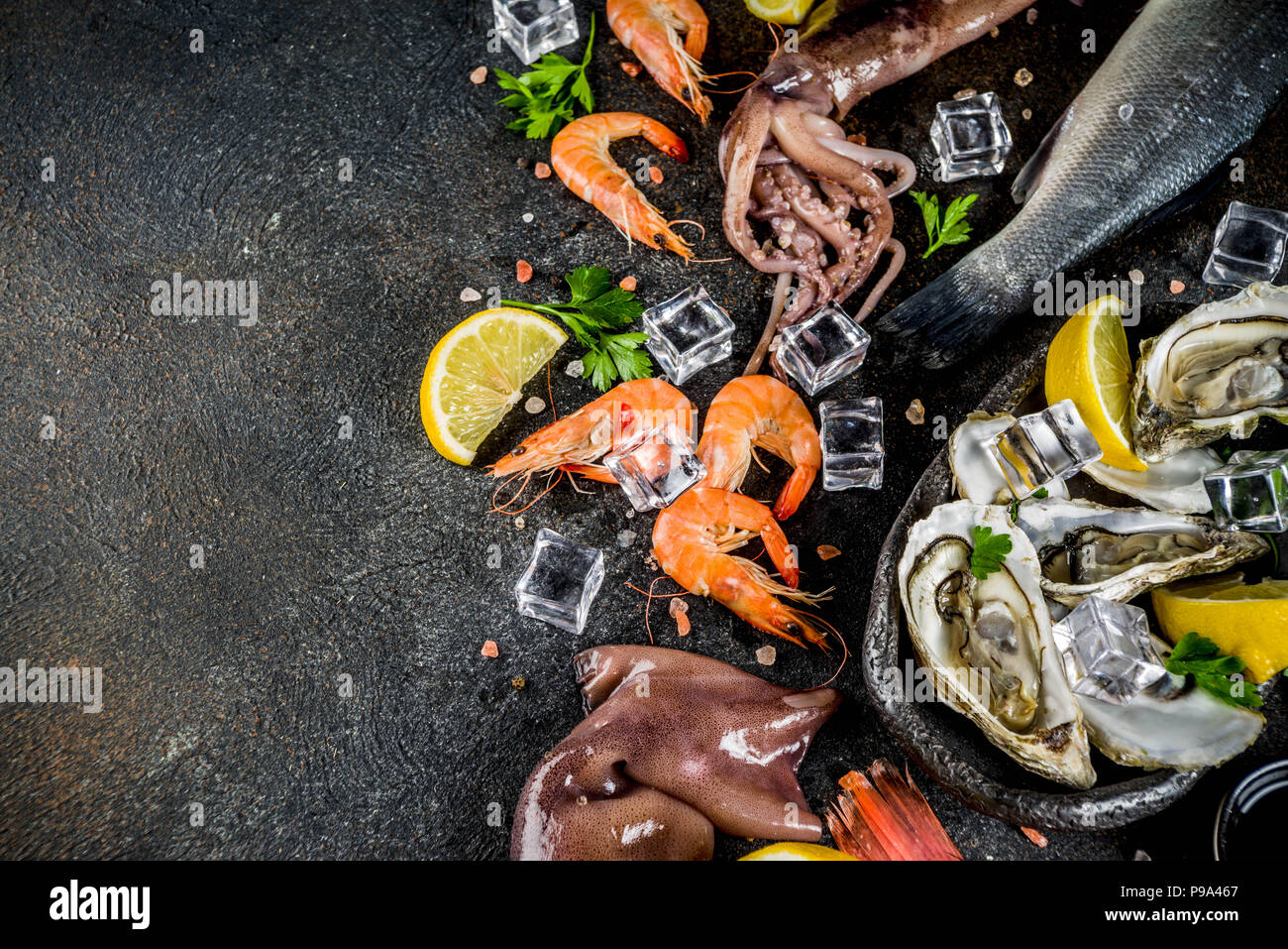 Fresh raw seafood squid shrimp oyster mussels fish with spices of herbs ...