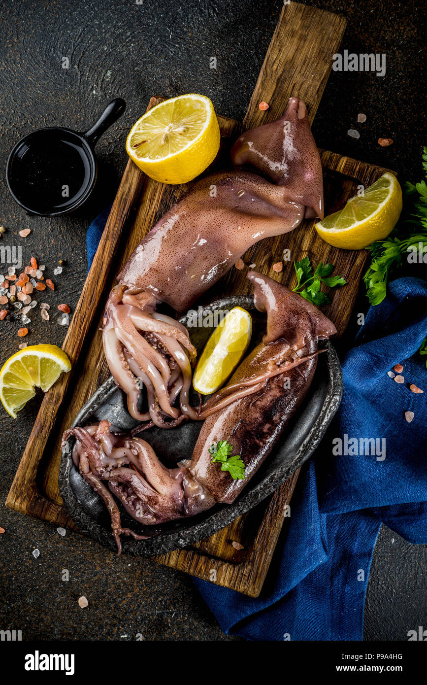 Fresh raw seafood, squid with lemon and light for preparation on a ...