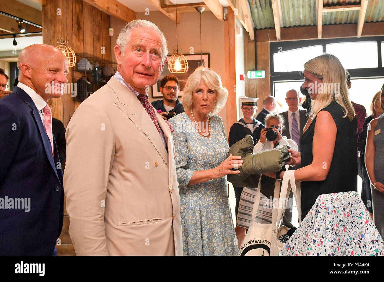 The Prince of Wales and the Duchess of Cornwall look at clothing inside ...