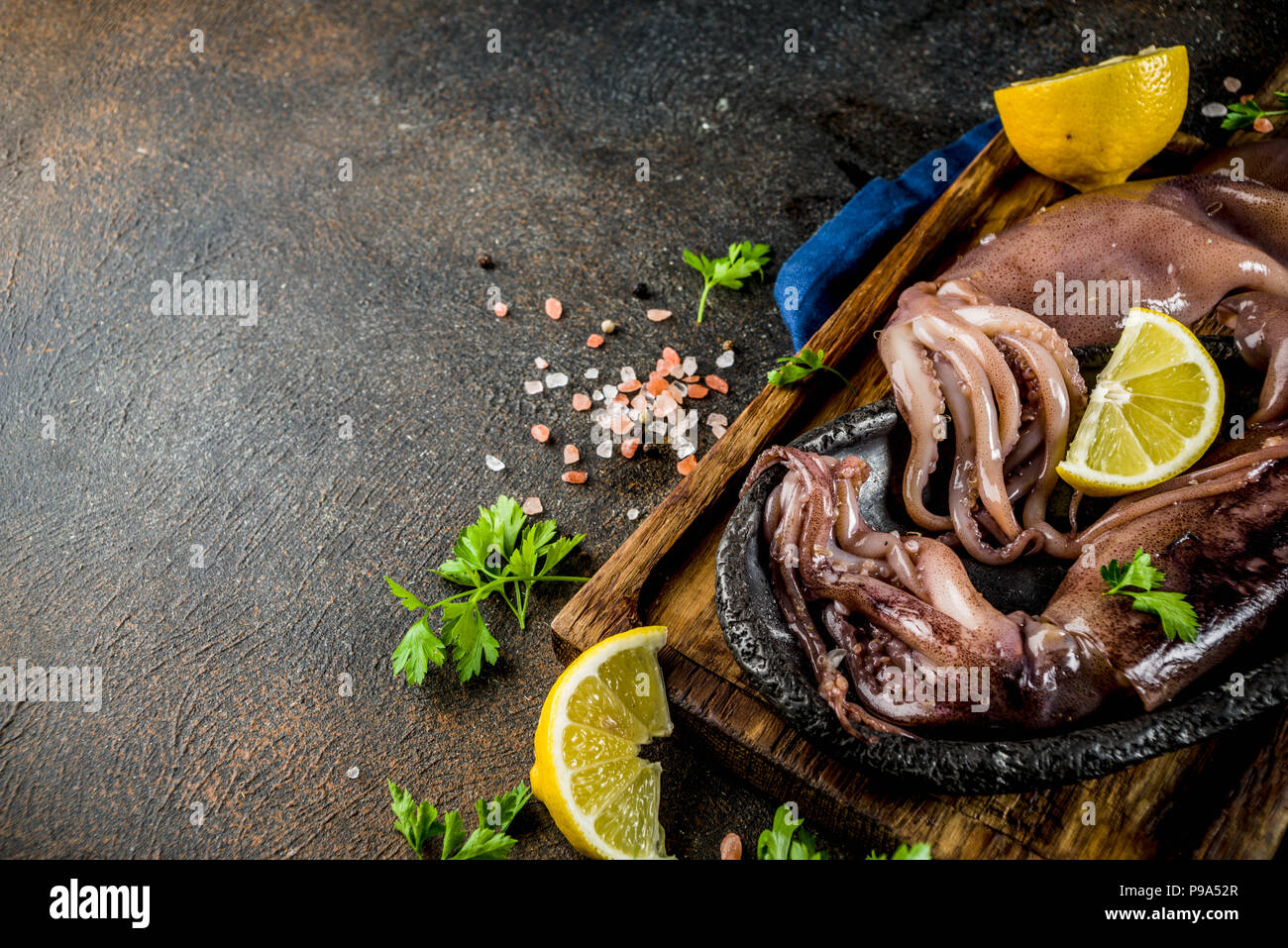 Fresh raw seafood, squid with lemon and light for preparation on a ...