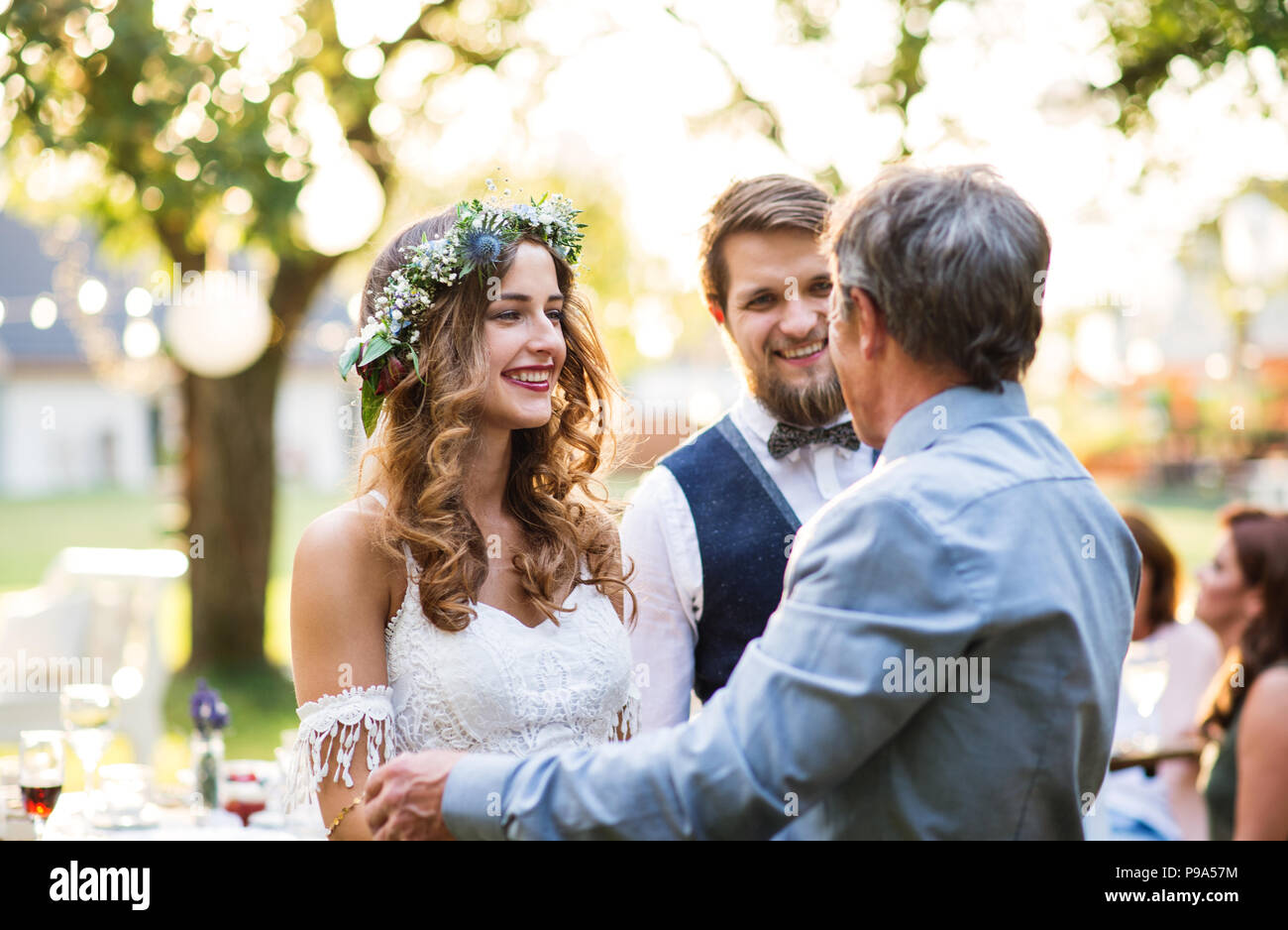 A father congratulating bride and groom at wedding reception in the ...