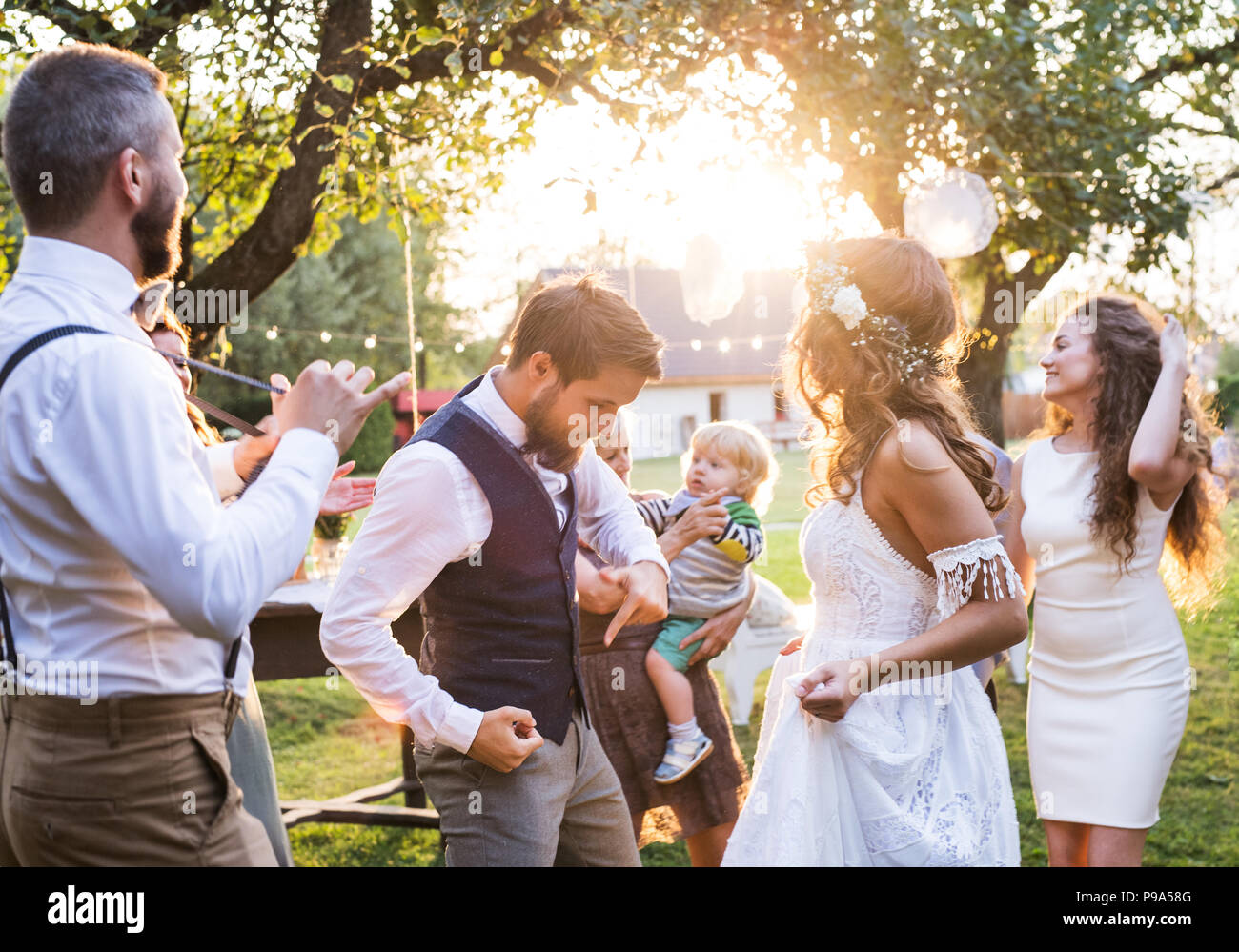 Bride and groom dancing at wedding reception outside in the backyard ...