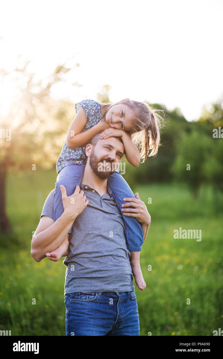 Father giving small daughter a piggyback ride in spring nature Stock ...