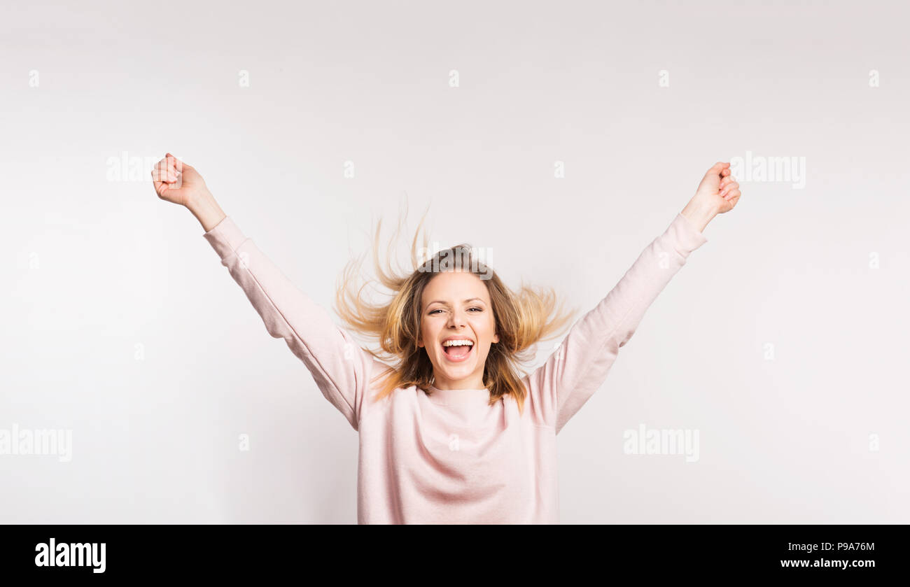 Portrait of a young beautiful delighted woman in studio on a white ...
