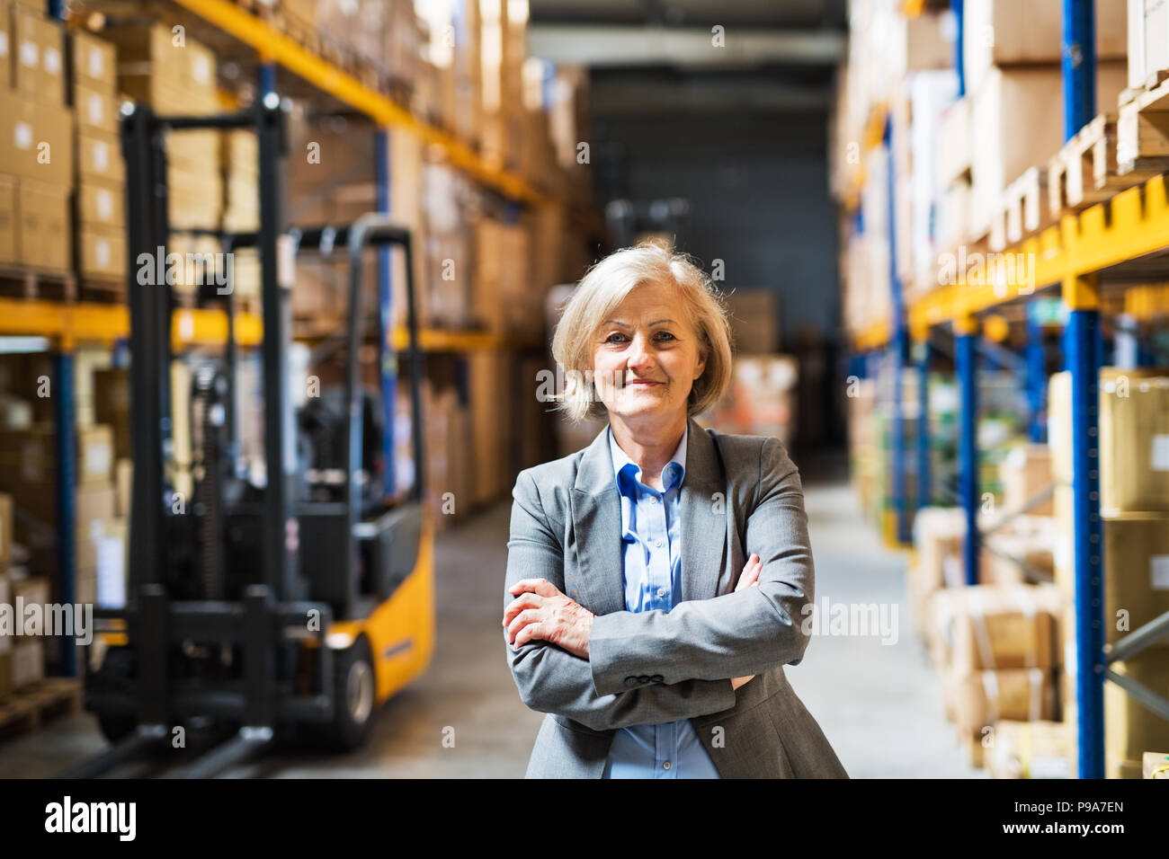 Senior woman warehouse manager or supervisor , arms crossed Stock Photo ...