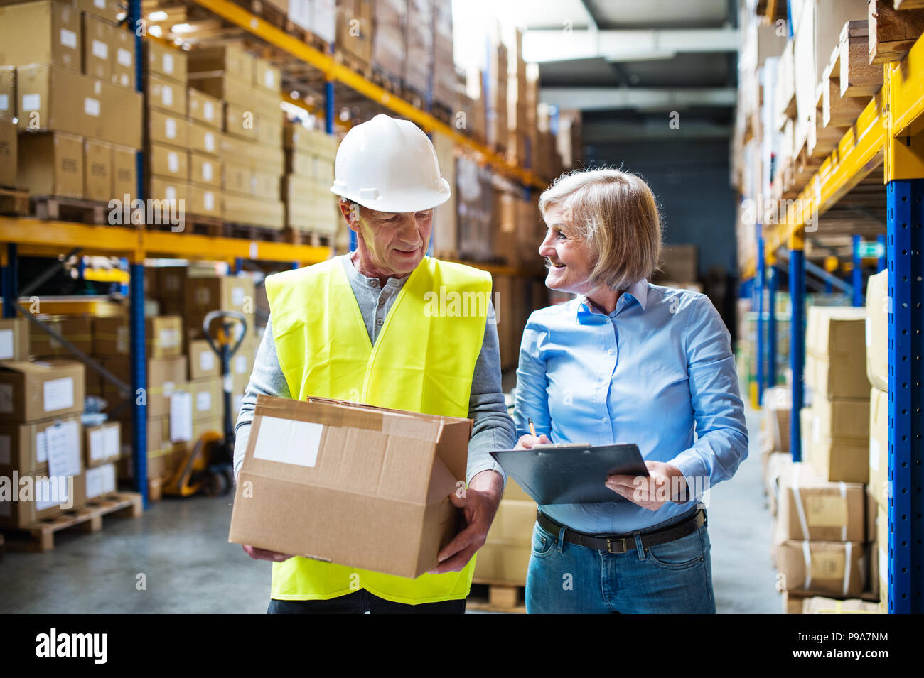 Senior woman manager and man worker working in a warehouse Stock Photo ...
