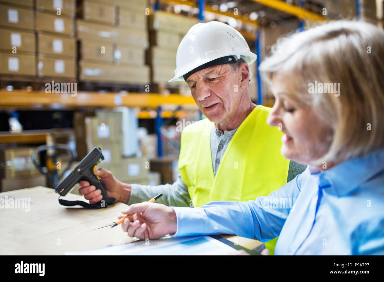 Senior woman manager and man worker working in a warehouse Stock Photo ...