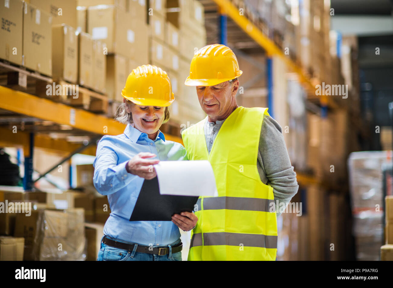 Senior woman manager and man worker working in a warehouse Stock Photo ...