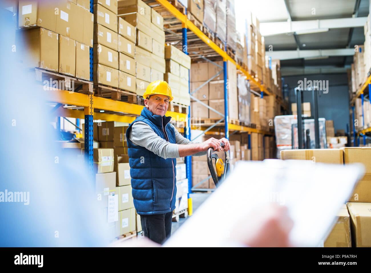 Senior woman manager and man worker working in a warehouse Stock Photo ...