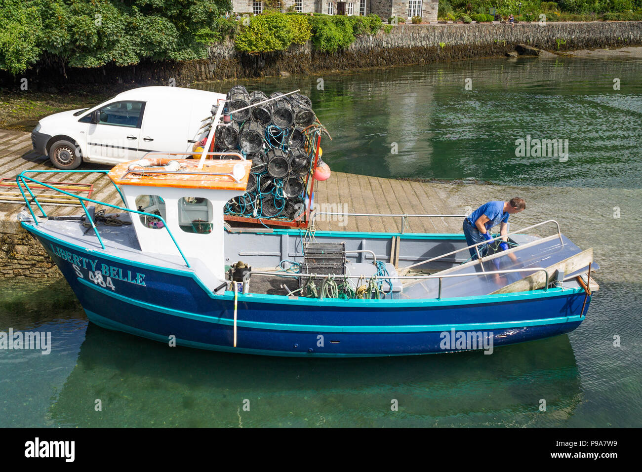 fisherman loading shrimp pots or shrimp traps onto his fishing boat ...