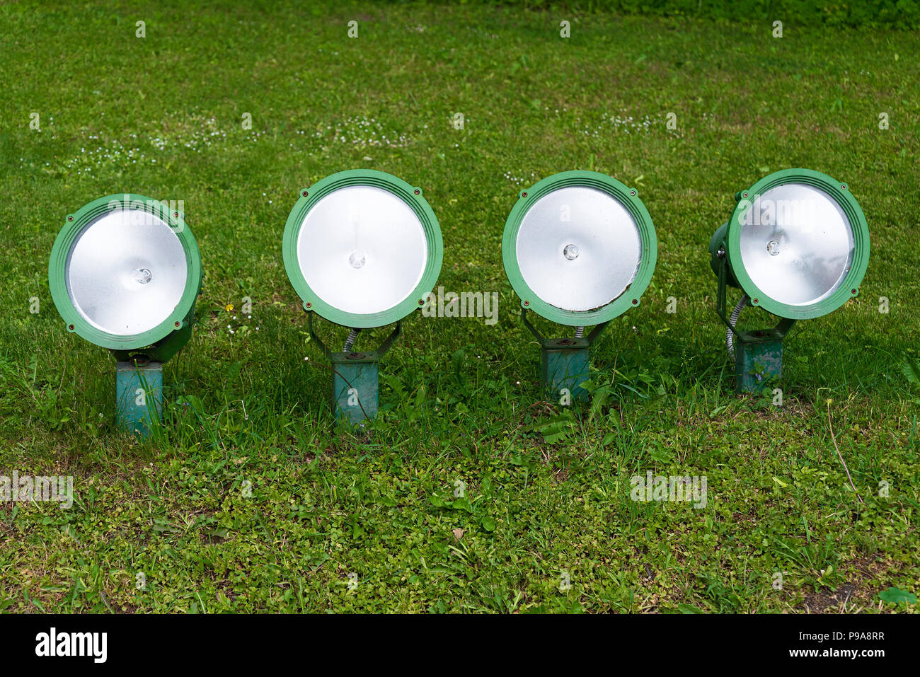 Four small spotlights on lawn grass on a summer day Stock Photo - Alamy
