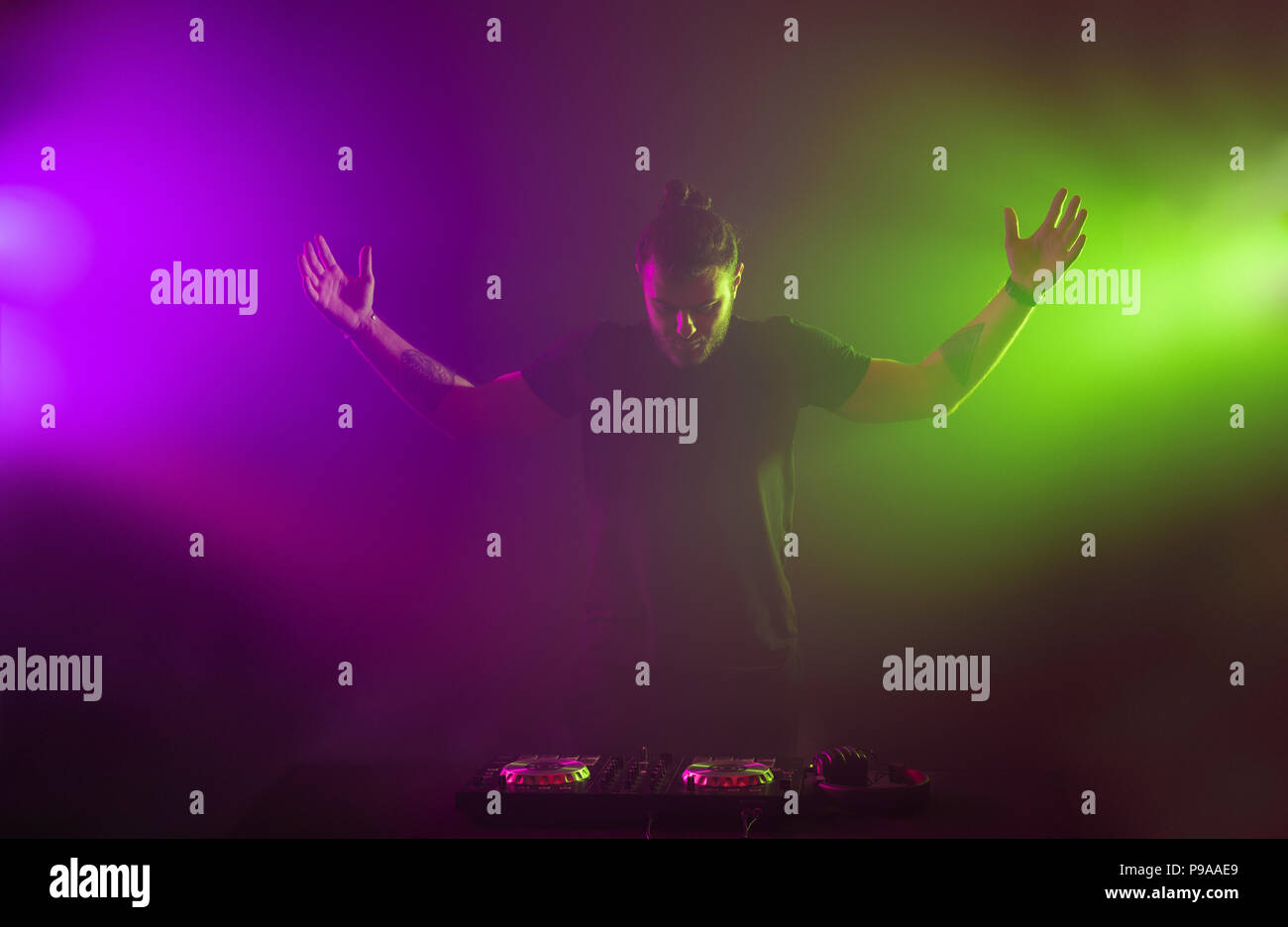 DJ at work mixing sound on her decks at a party or night club with ...