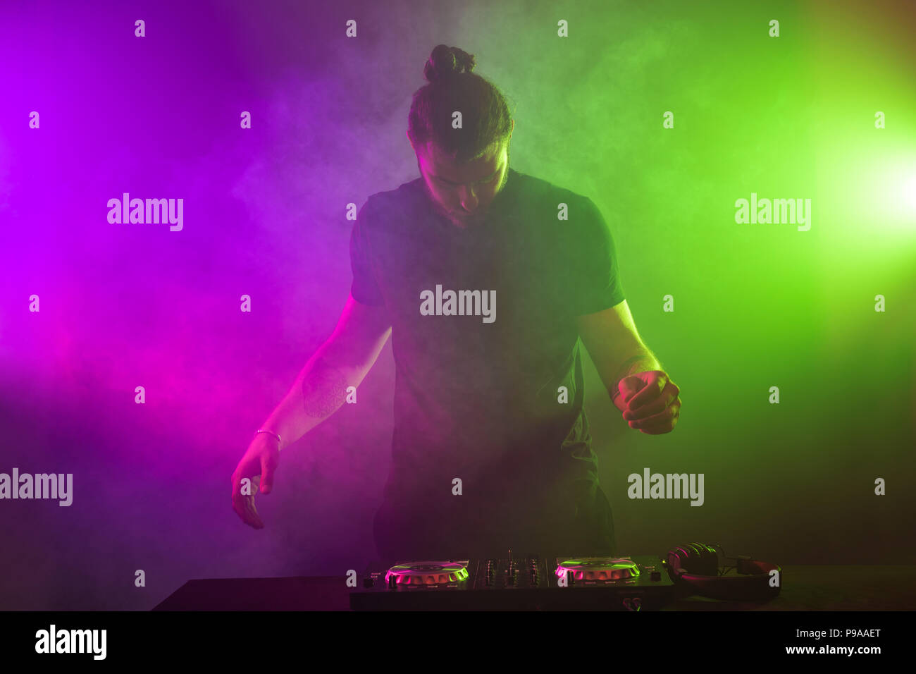 DJ at work mixing sound on her decks at a party or night club with ...