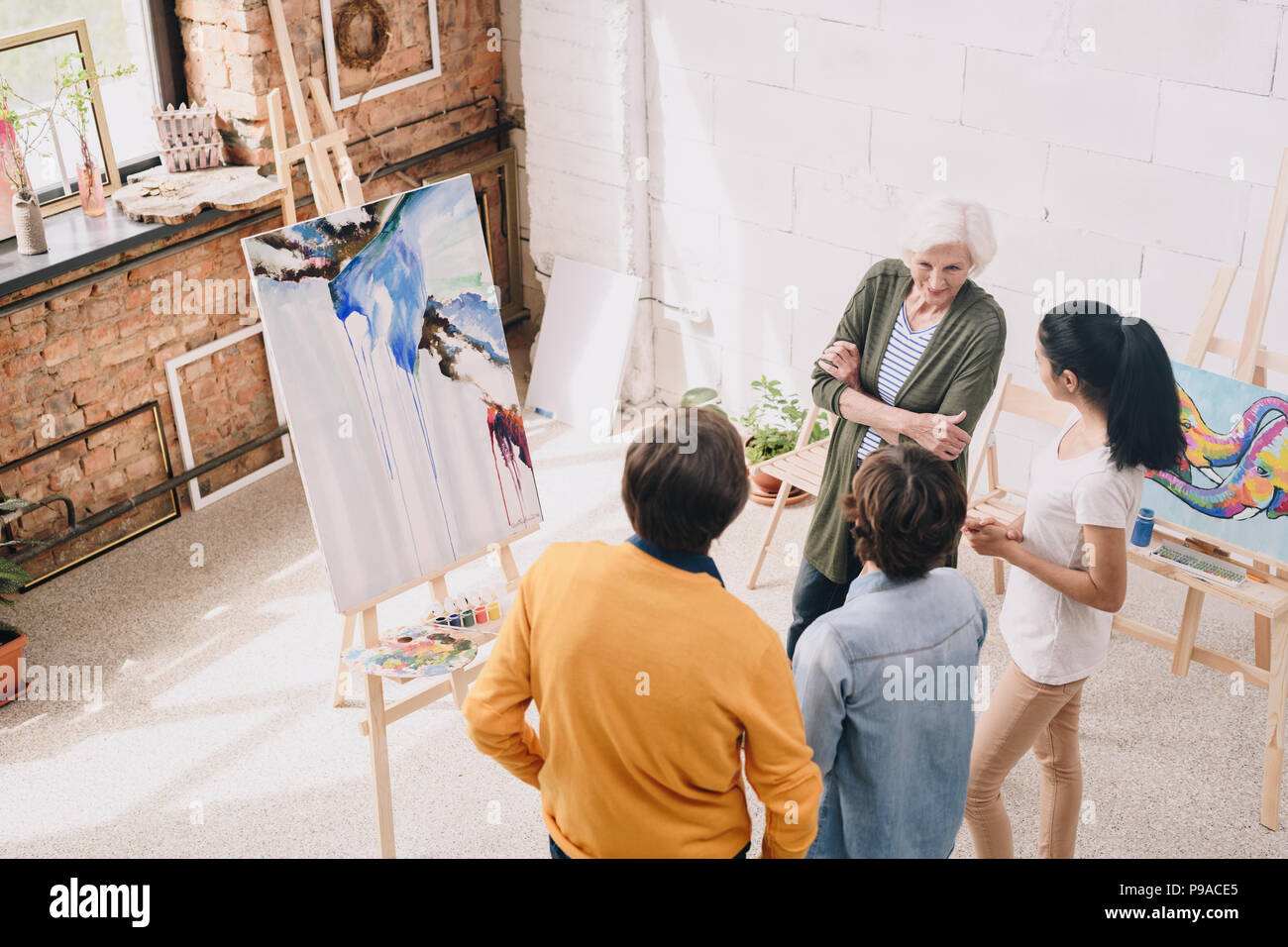 High angle portrait of artists presenting watercolor painting to ...