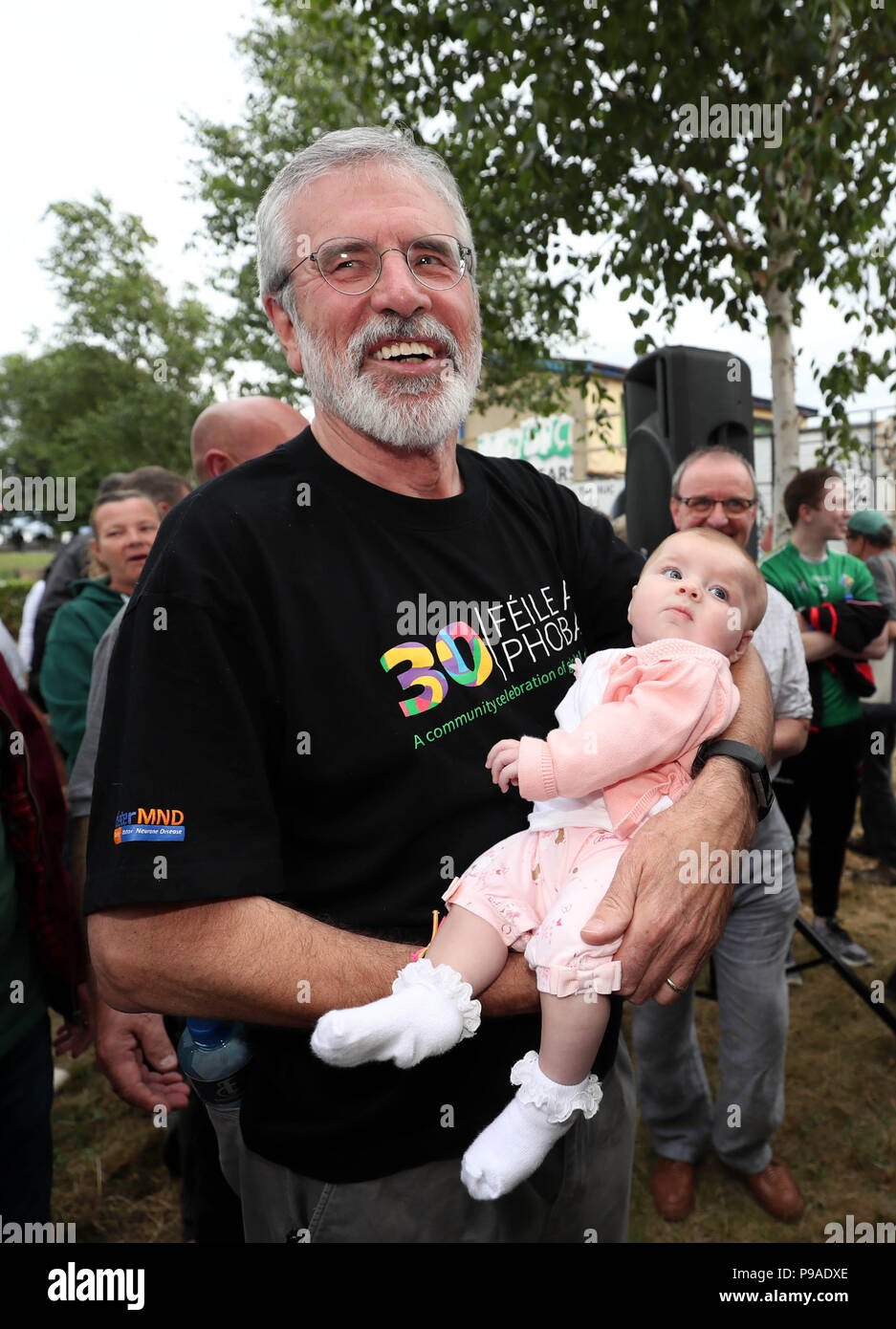 Gerry Adams hold a child for a photograph for the parents at a rally ...