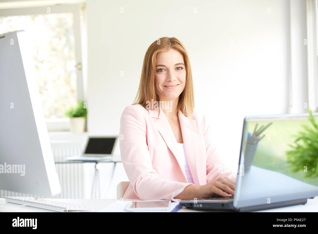 Beautiful young financial assistant businesswoman working on laptop ...