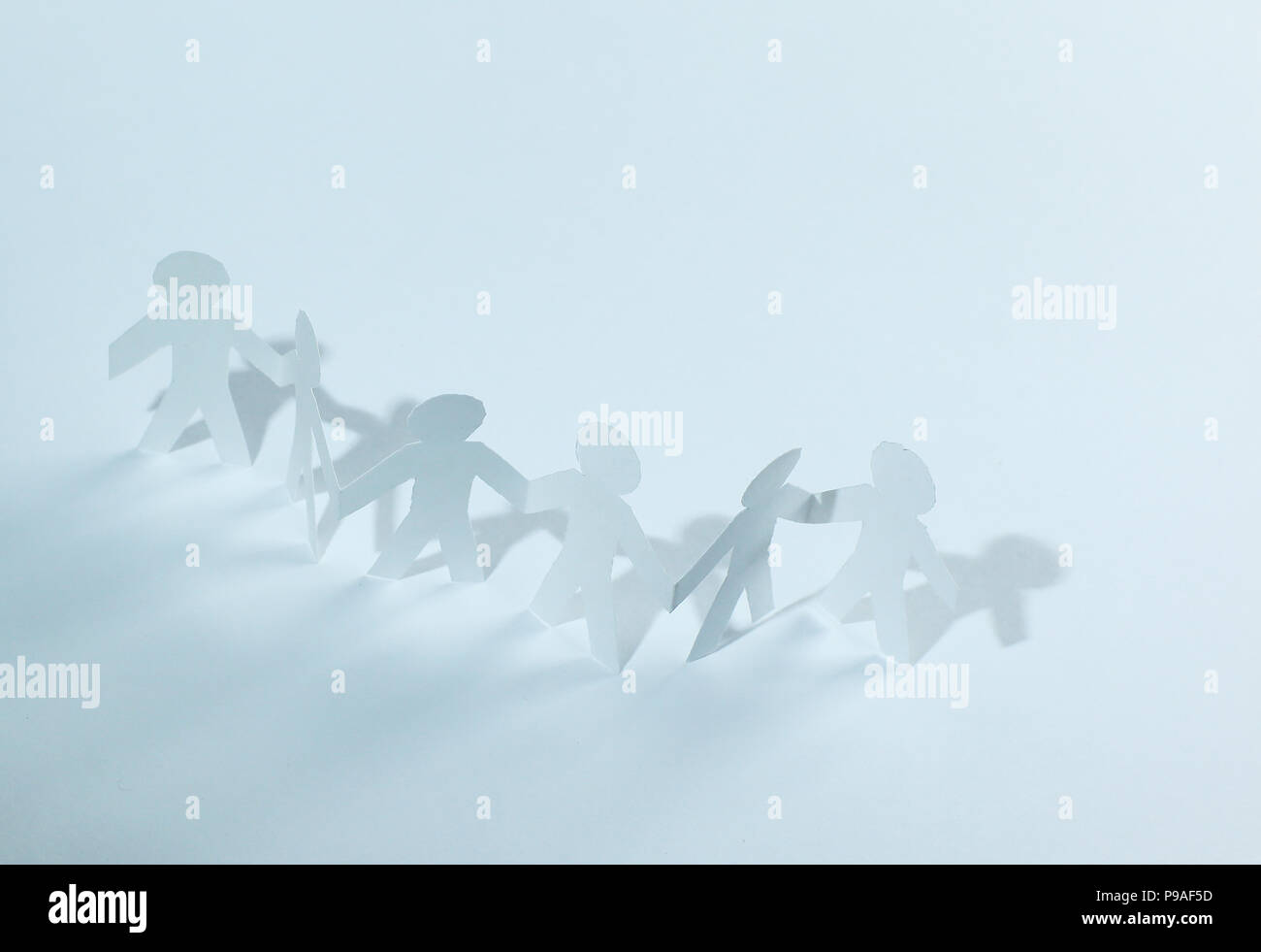 group of paper men holding each other's hands Stock Photo - Alamy