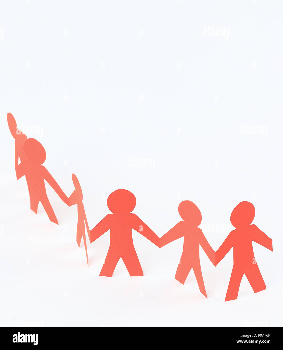 three teams paper men taking each other's hands Stock Photo - Alamy