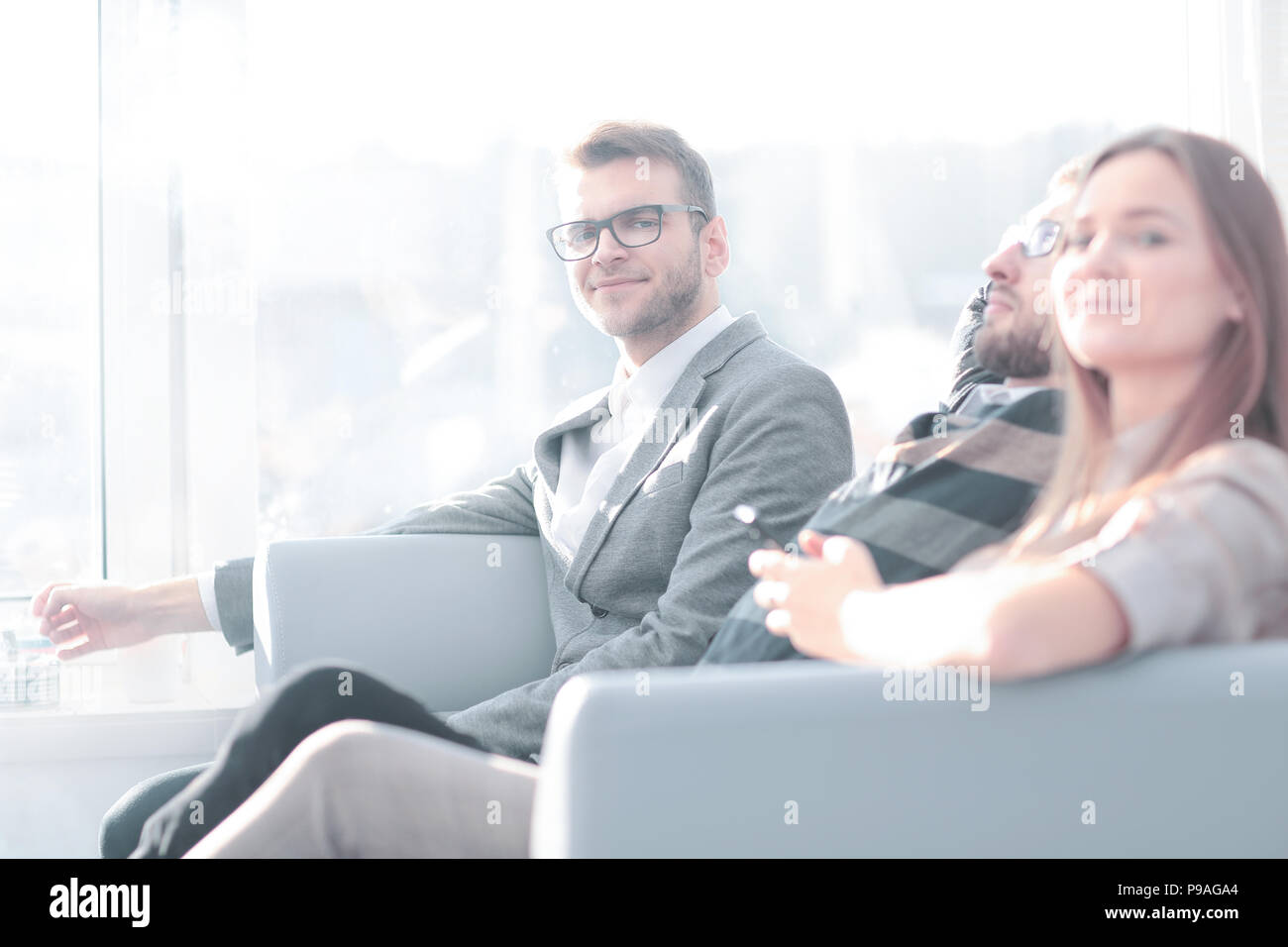 business team sitting on the couch during work break Stock Photo - Alamy