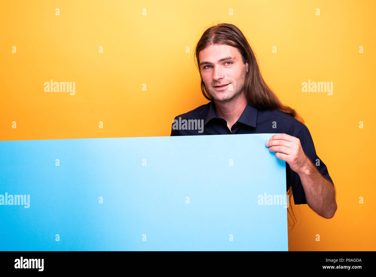 Handsome male adult holding empty advertise banner Stock Photo - Alamy