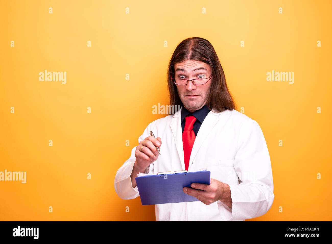 Crazy male doctor looking funny to clipboard Stock Photo - Alamy