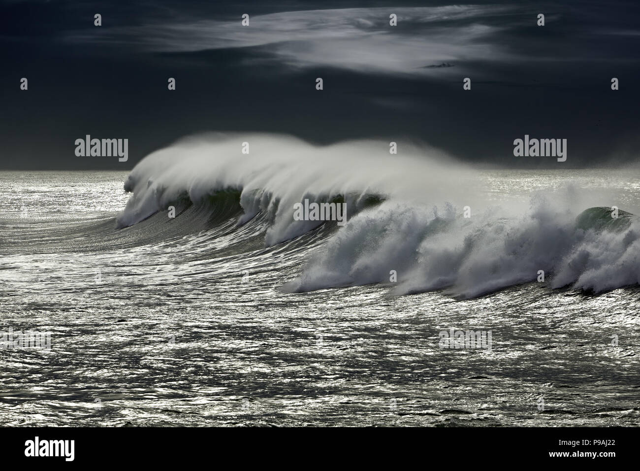 Windy wave in a glistening sea. Enhanced sky Stock Photo - Alamy